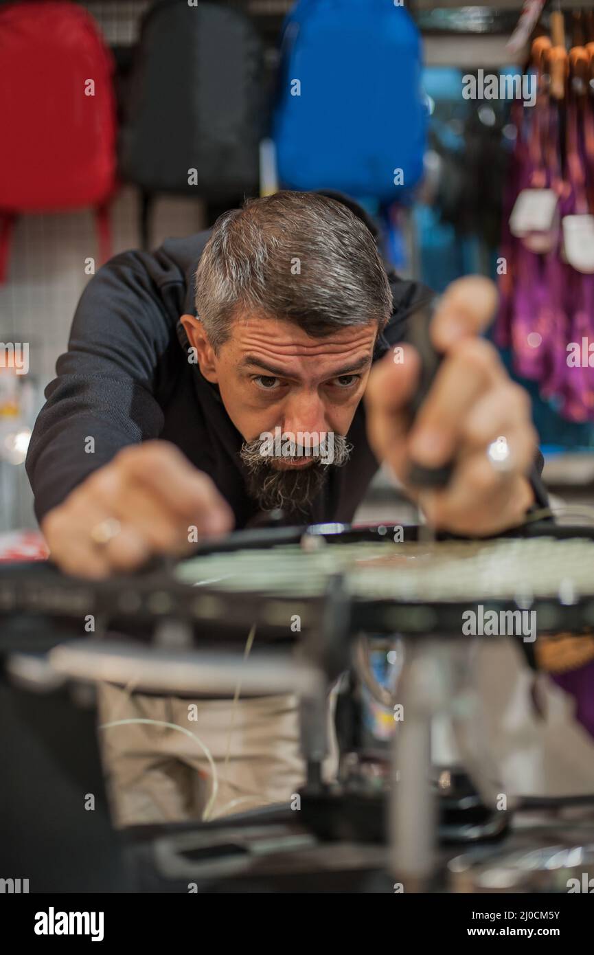Stringing Machine. Detail of tennis stringer hands while holding awl ...