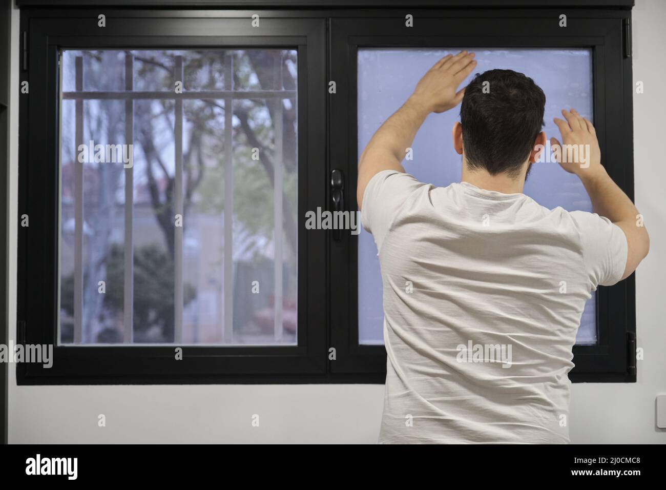 Man installing frosted window vinyl on wet window glass Stock Photo - Alamy