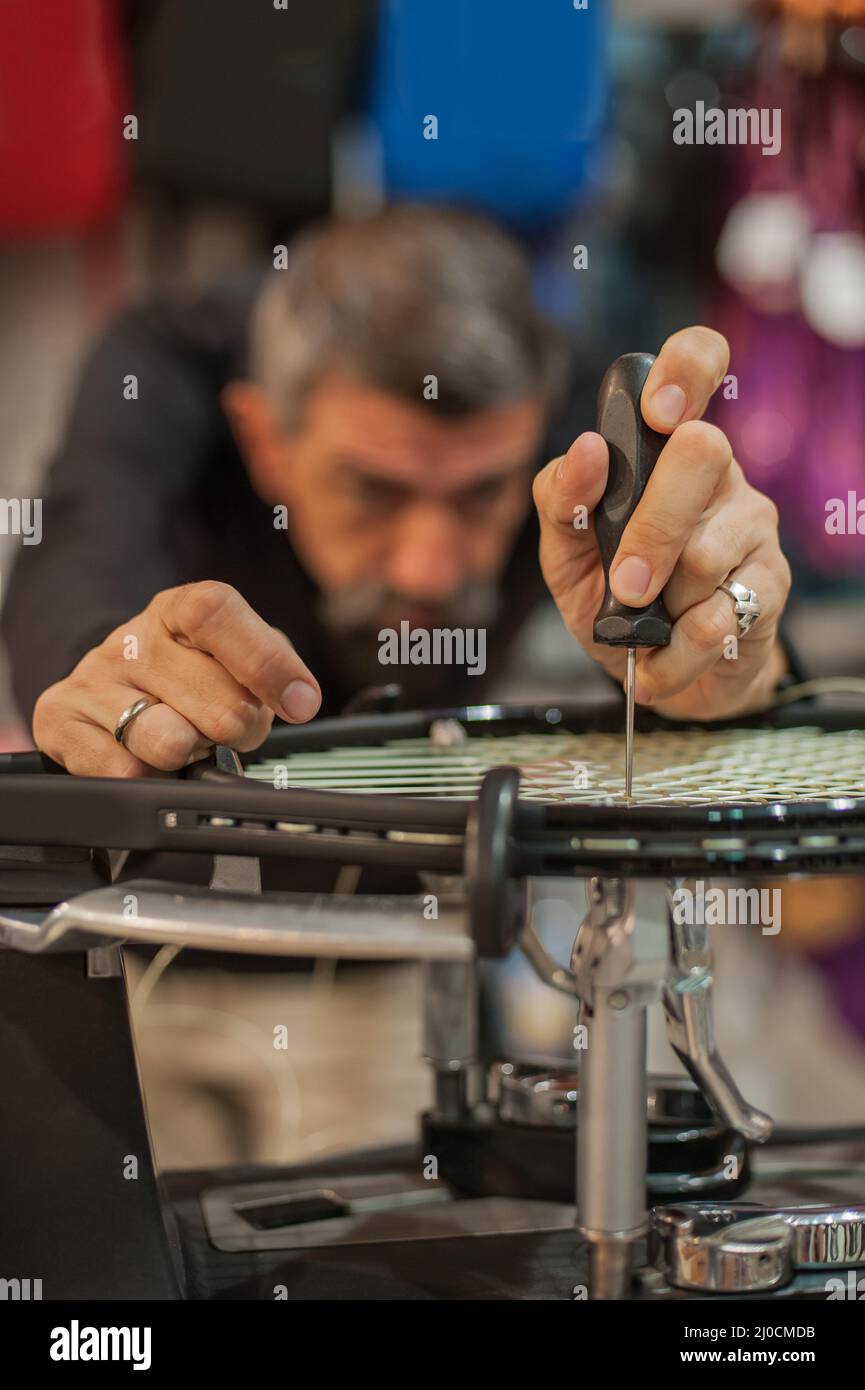 Stringing Machine. Detail of tennis stringer hands while holding awl ...