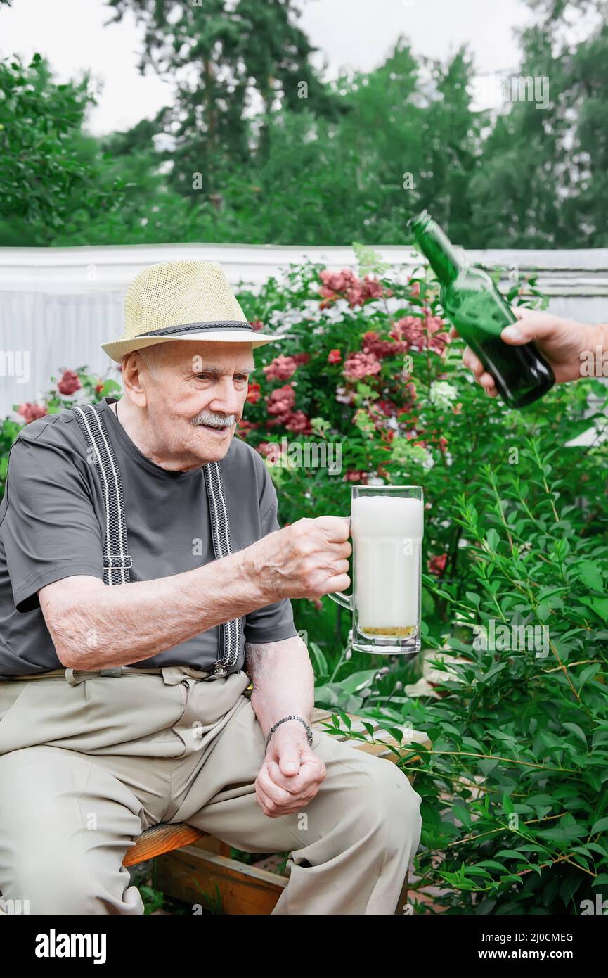old man with a glass and a bottle of foamy beer Stock Photo - Alamy