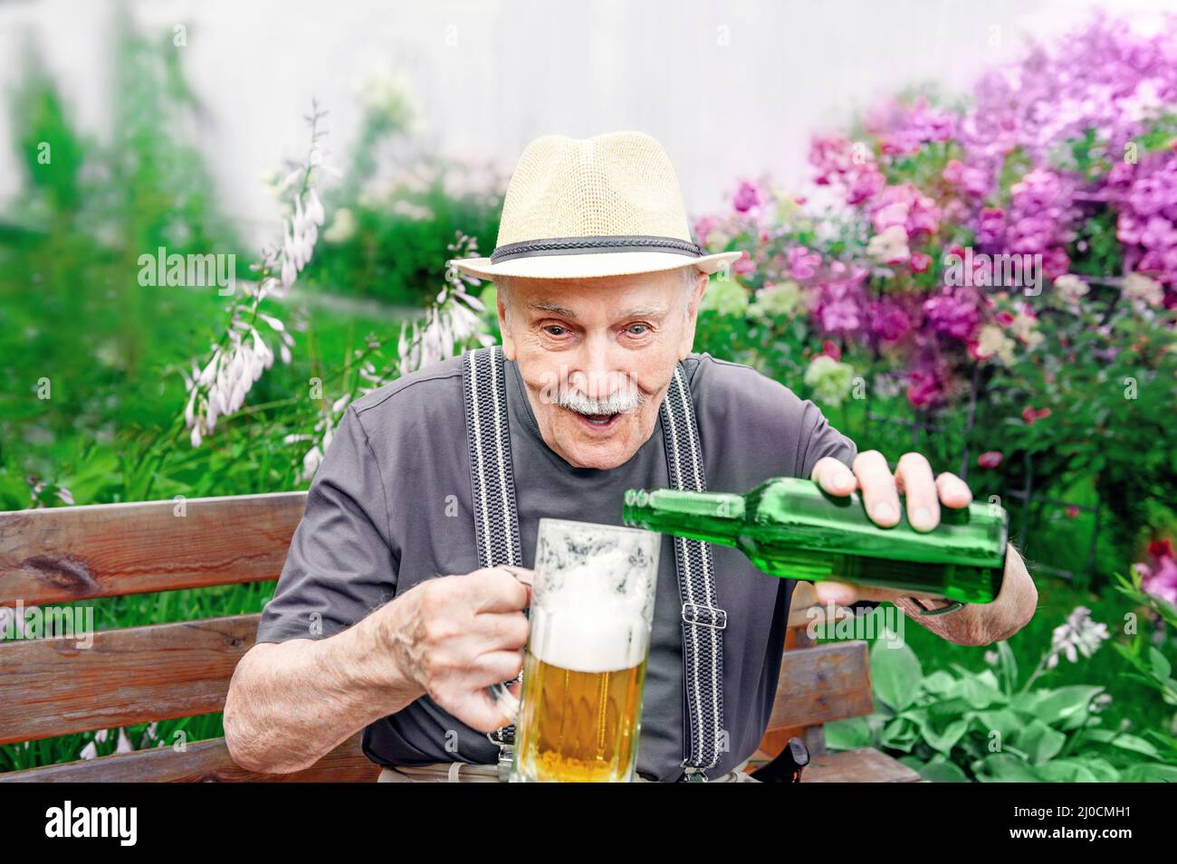 old man pours beer from a bottle into a beer glass Stock Photo - Alamy