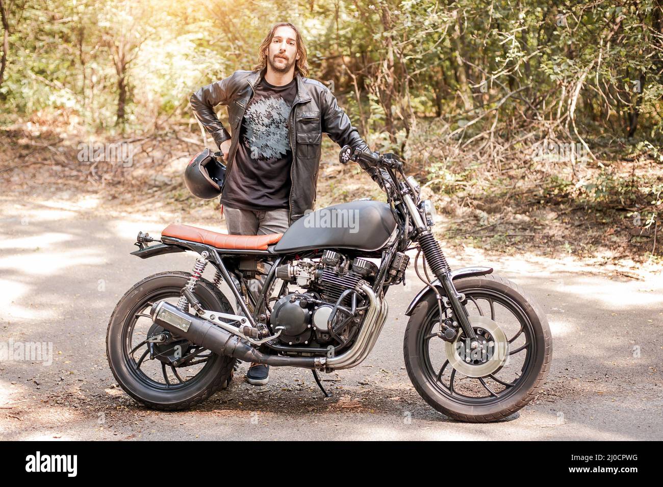 Handsome motorcyclist in black posing of his super sport motorcycle ...