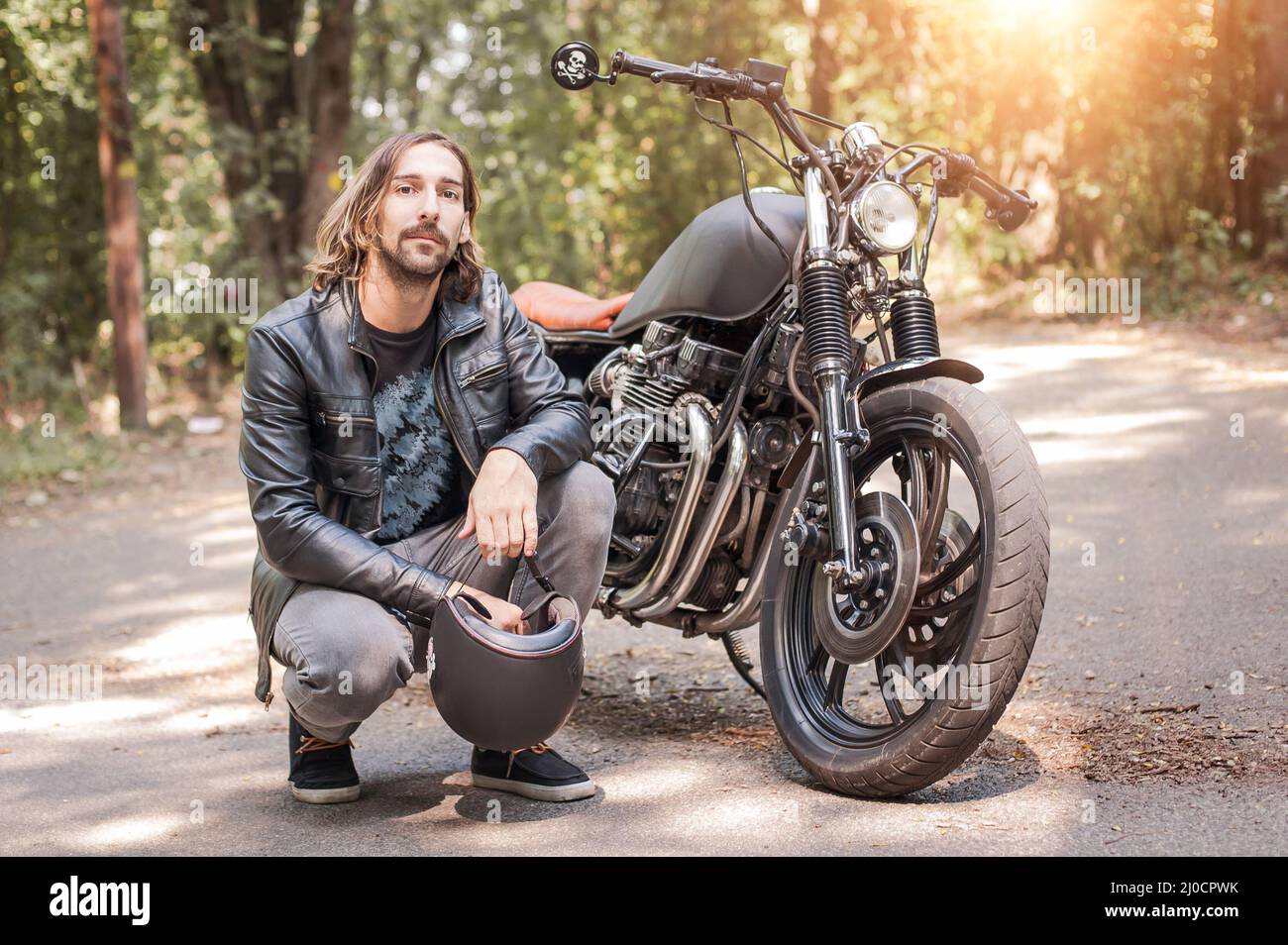 Handsome motorcyclist in black posing in front of his super sport ...