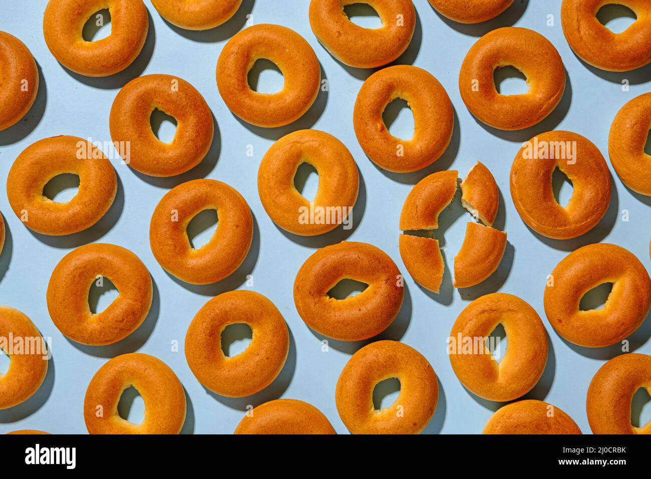 Fresh cripsy bagels background texture with one broken into four pieces ...