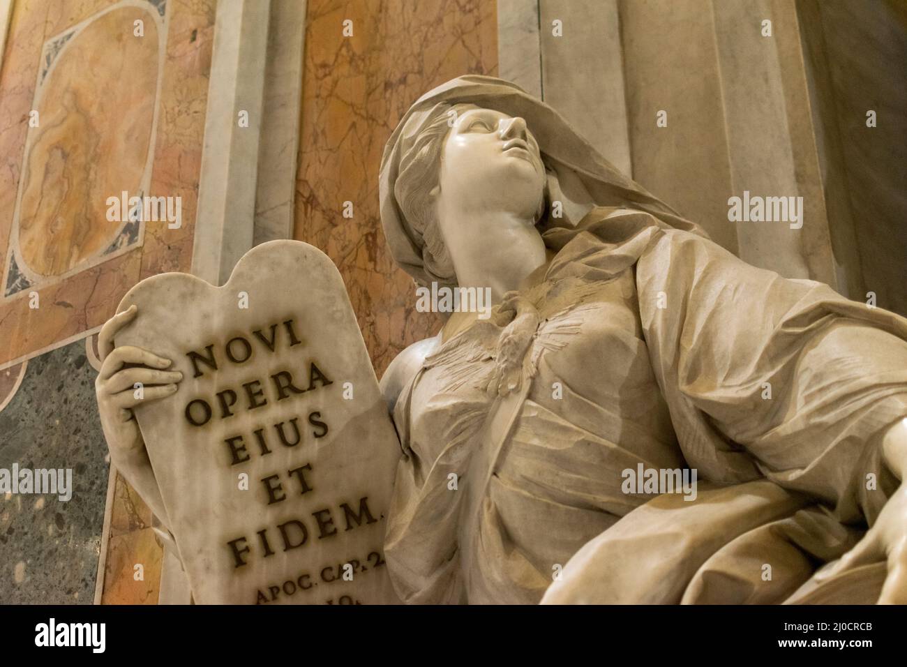 A woman sculpture with a writing in her hands "I know his works and ...