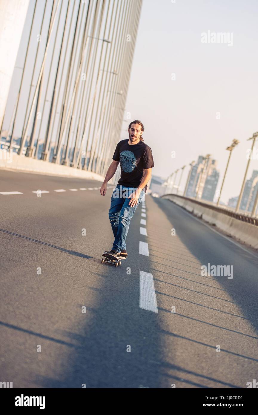 Professional skateboarder riding a skate over a city road bridge ...