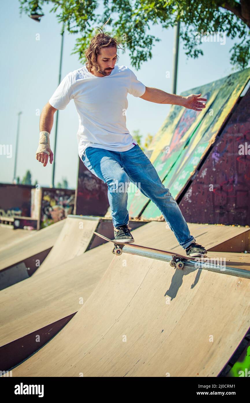 Action shot of a skateboarder skating at the skate park with concrete ...