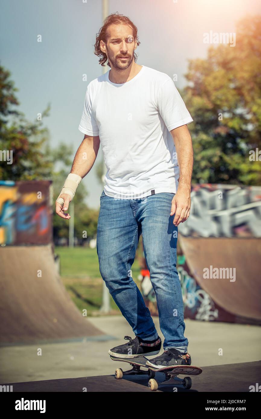Action shot of a skateboarder skating at the skate park with concrete ...