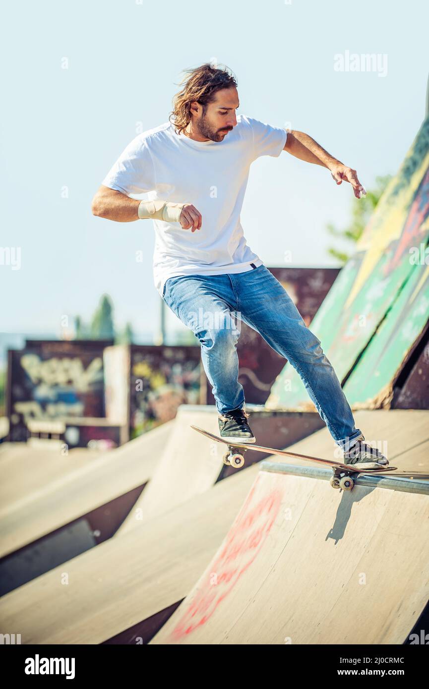 Action shot of a skateboarder skating at the skate park with concrete ...