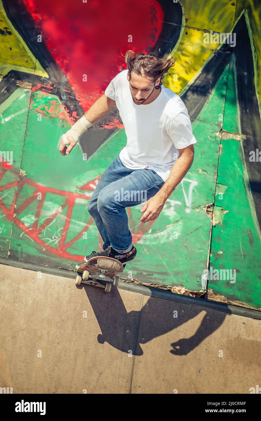 Action shot of a skateboarder skating at the skate park with concrete ...