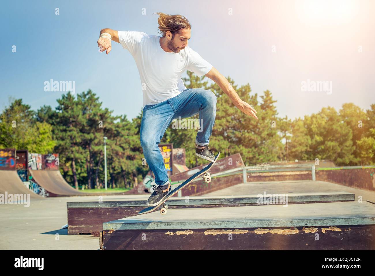 Action shot of a skateboarder skating at the skate park with concrete ...