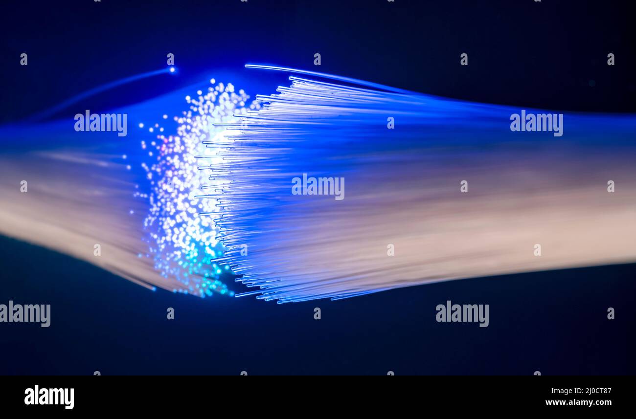 Blue illuminated optical fibers closeup in dark back Stock Photo - Alamy