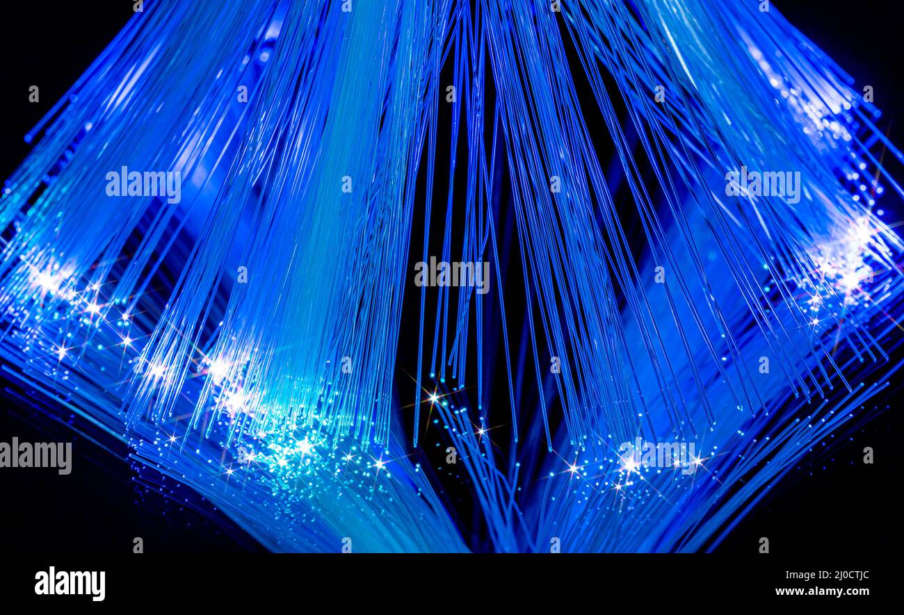 Blue illuminated optical fiber closeup in black back Stock Photo - Alamy