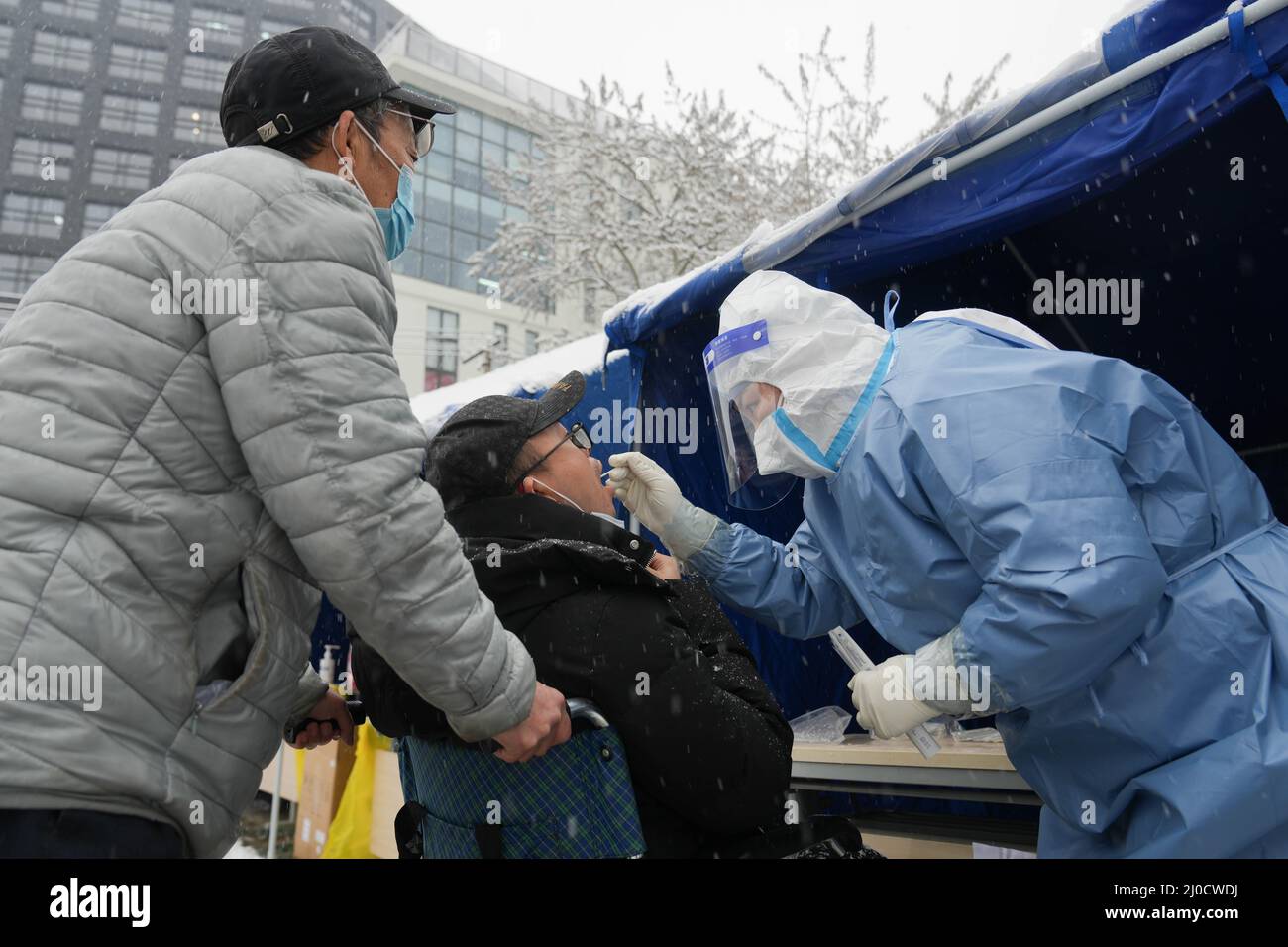 Beijing, China. 18th Mar, 2022. A medical worker takes a swab sample ...