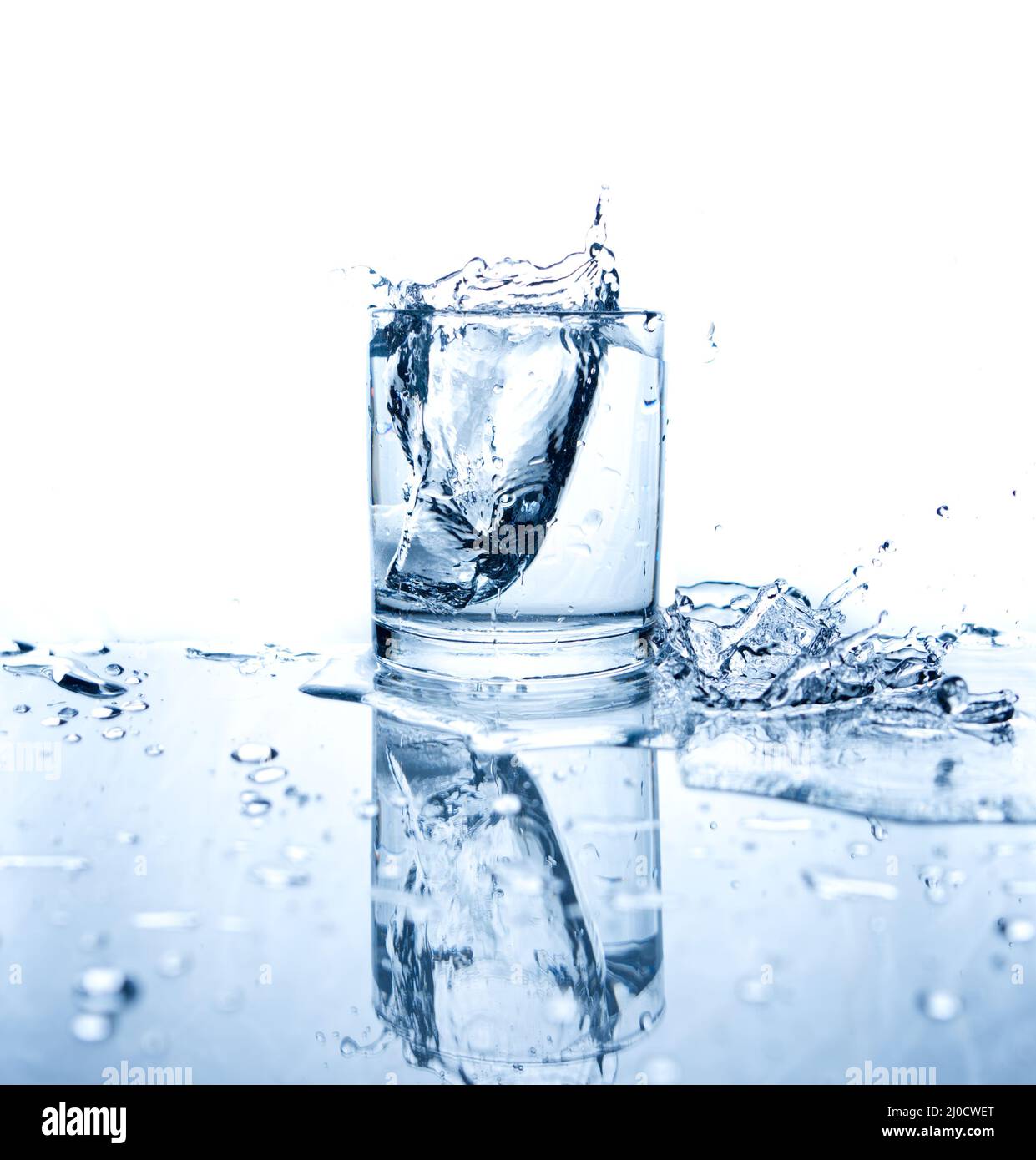 Drinking water splashed with ice in glass on white background with ...