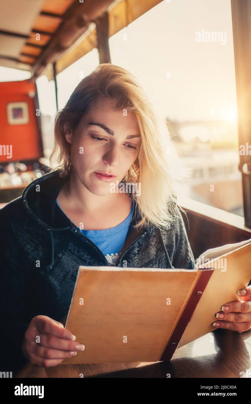 Pretty woman choosing food from menu in restaurant Stock Photo - Alamy