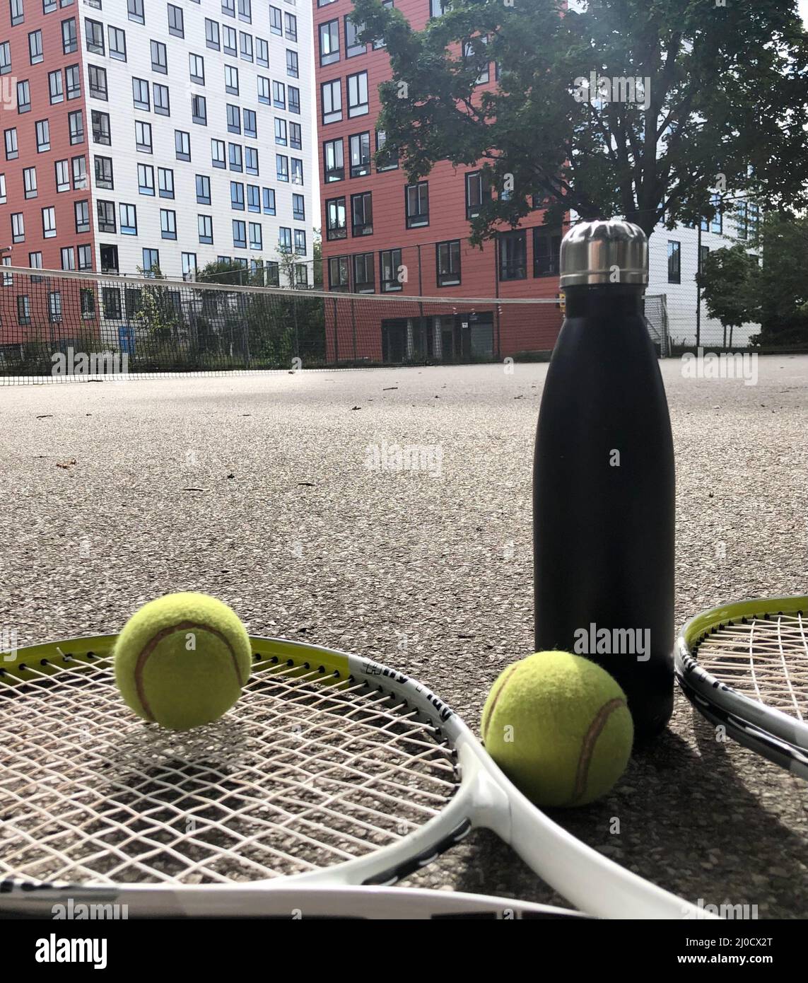 Photo of tennis ball, racket and water bottle on the ground Stock Photo ...