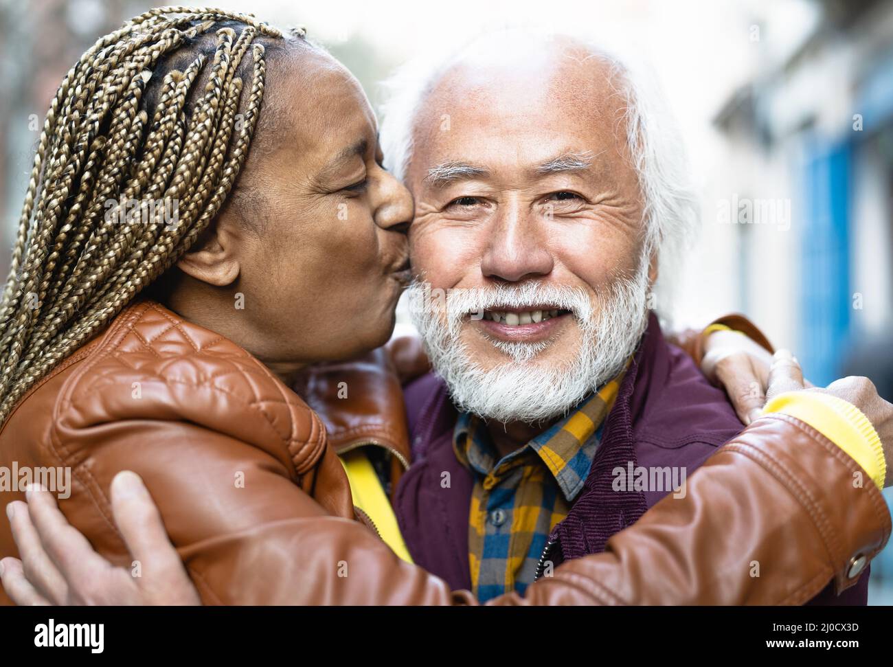 Happy multiracial senior couple having tender moments in city - Elderly ...