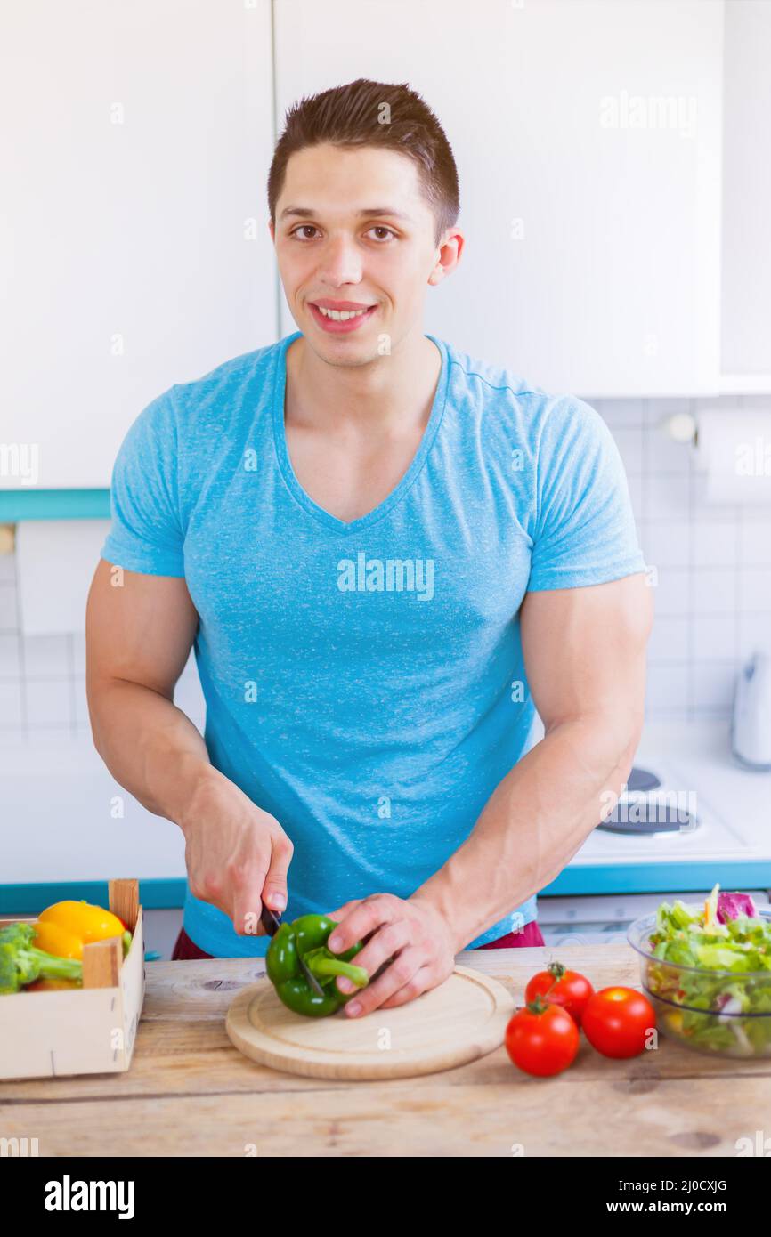 Prepare food cut vegetables young man lunch in the kitchen portrait ...