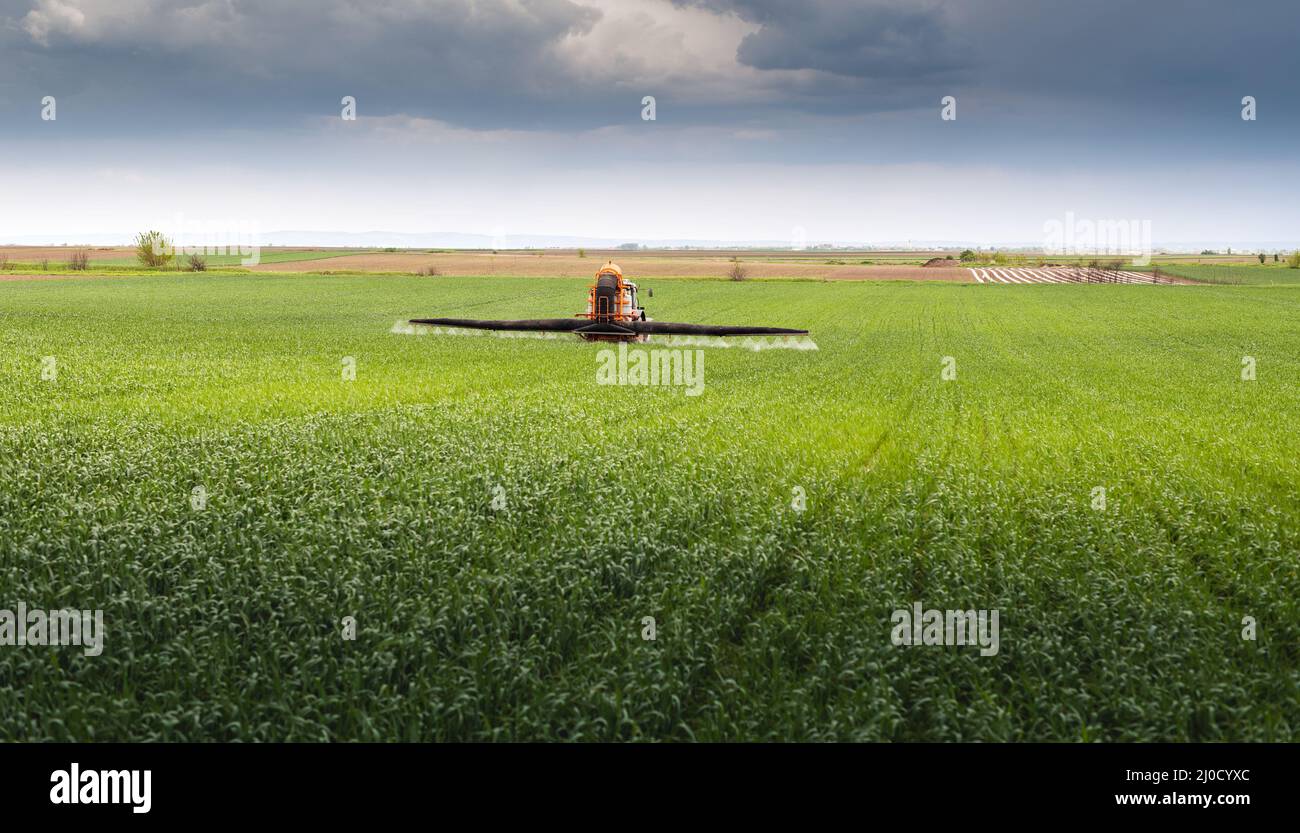 Farmer with tractor seeding - sowing crops at agricultural field ...