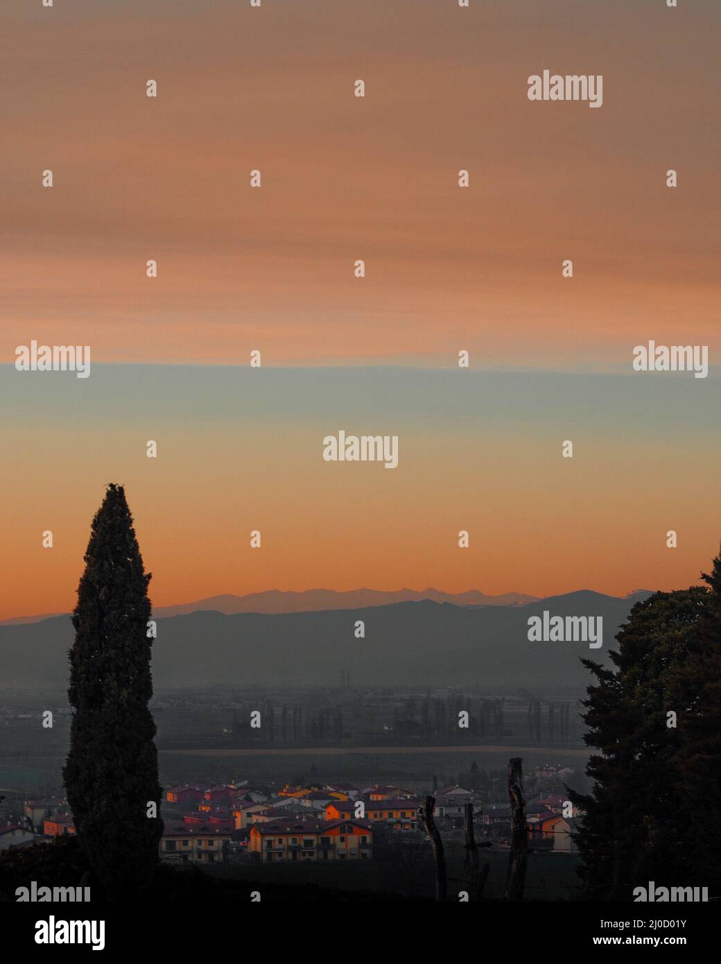 Vertical shot of a scenic sunset over the town Stock Photo - Alamy