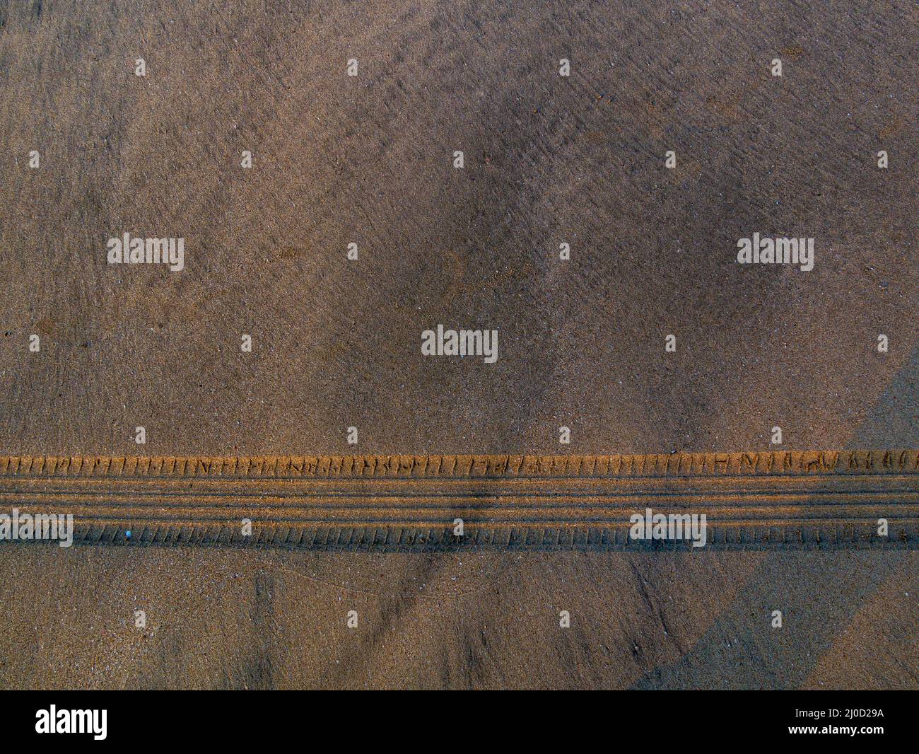 Impression of tyre on Sea sand Stock Photo - Alamy