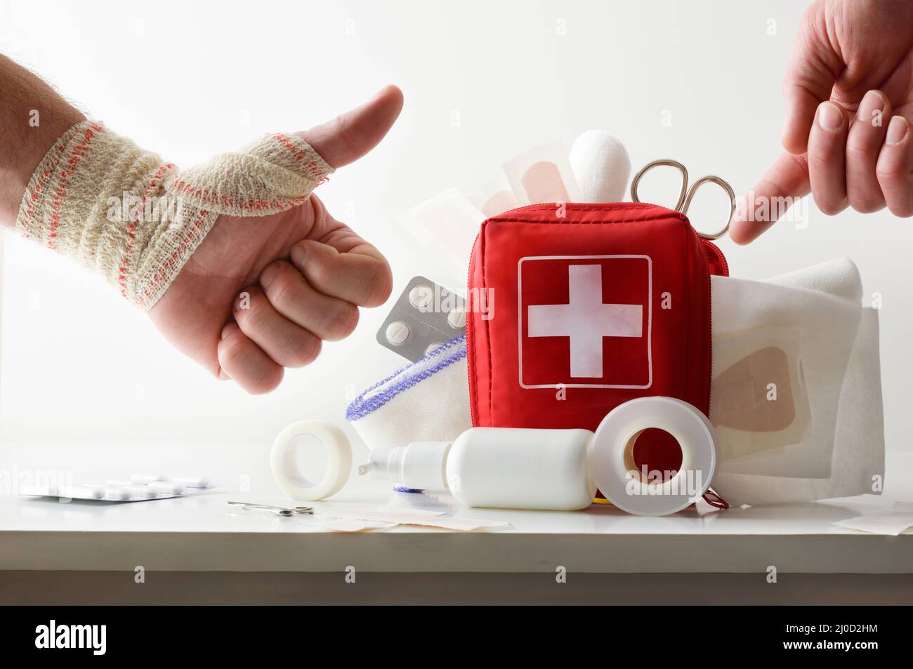 Hand pointing at travel portable first aid bag full of medical objects ...
