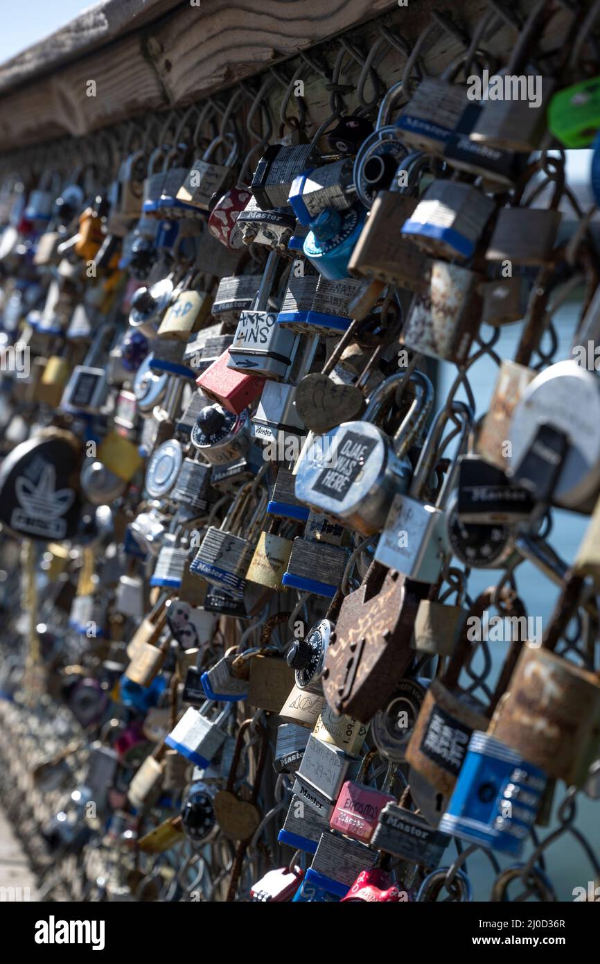 Padlocks chained to a fence over a bridge to show commitment of love ...