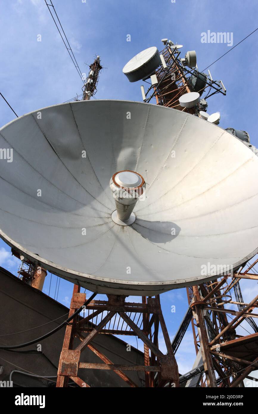The old bent satellite antenna on rusty tower Stock Photo - Alamy