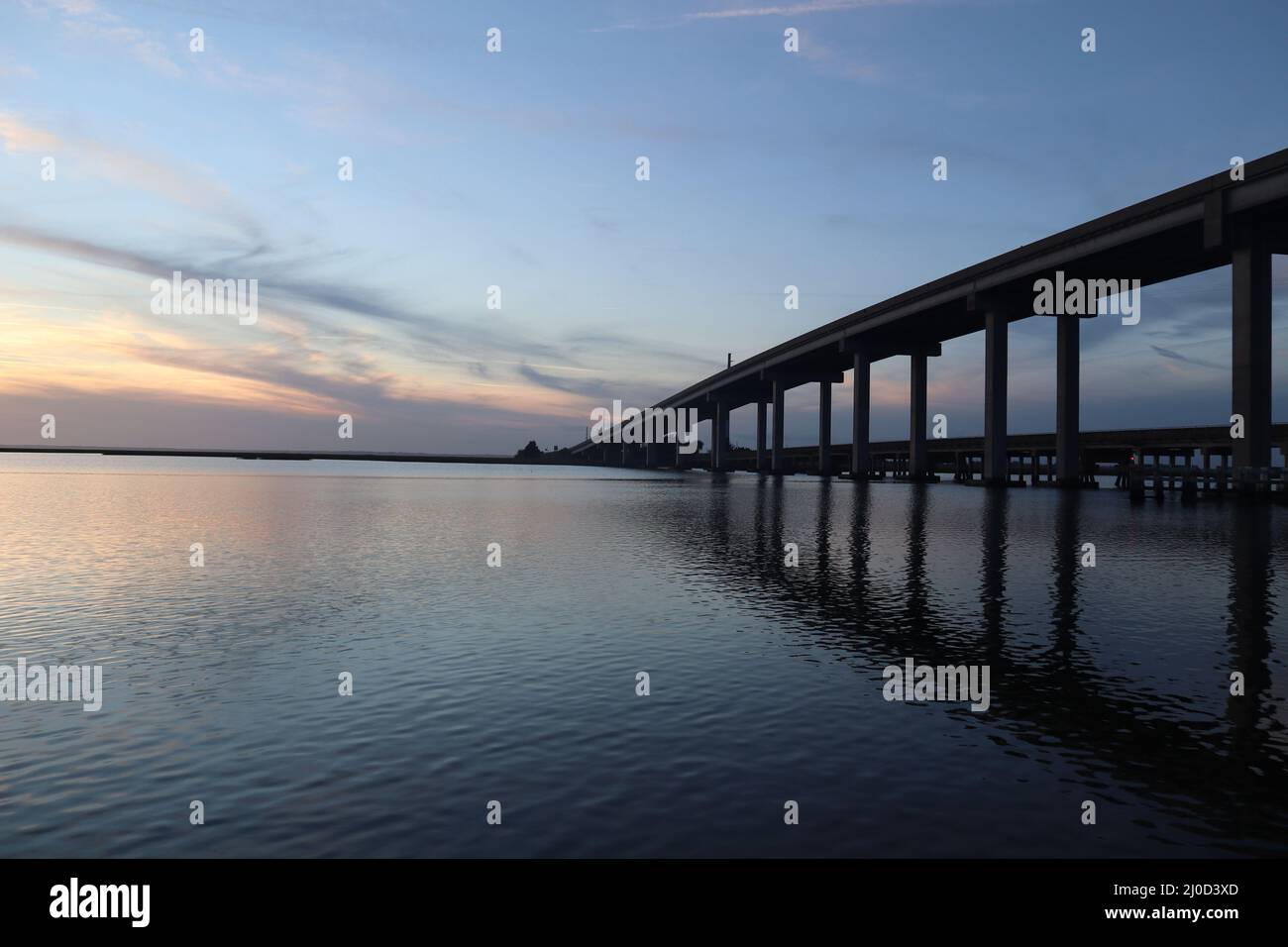 Scenic view of a wooden pier over a body of water with a cloudy sky in ...