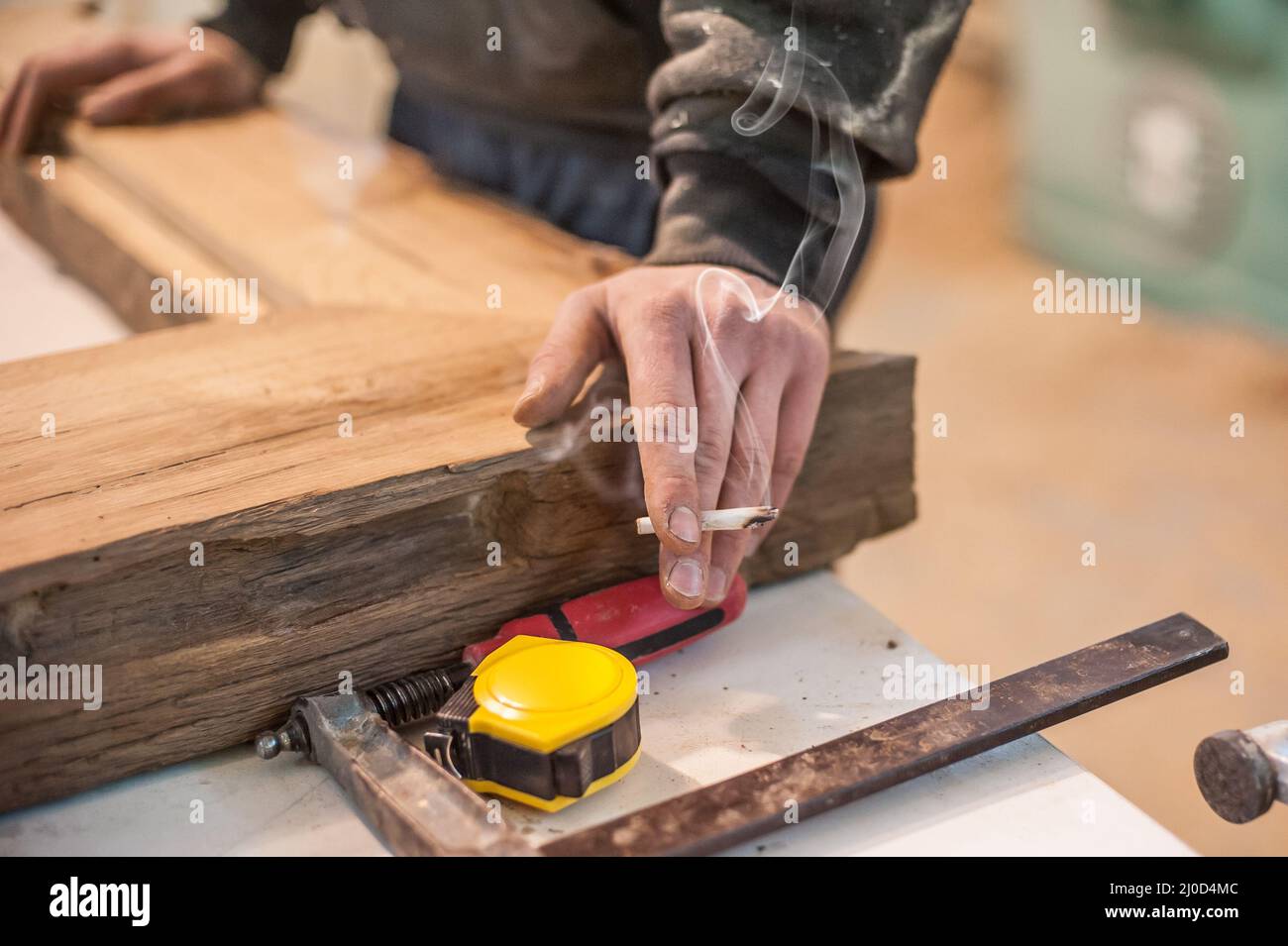Carpenter smoking cigarette in workshop Stock Photo - Alamy
