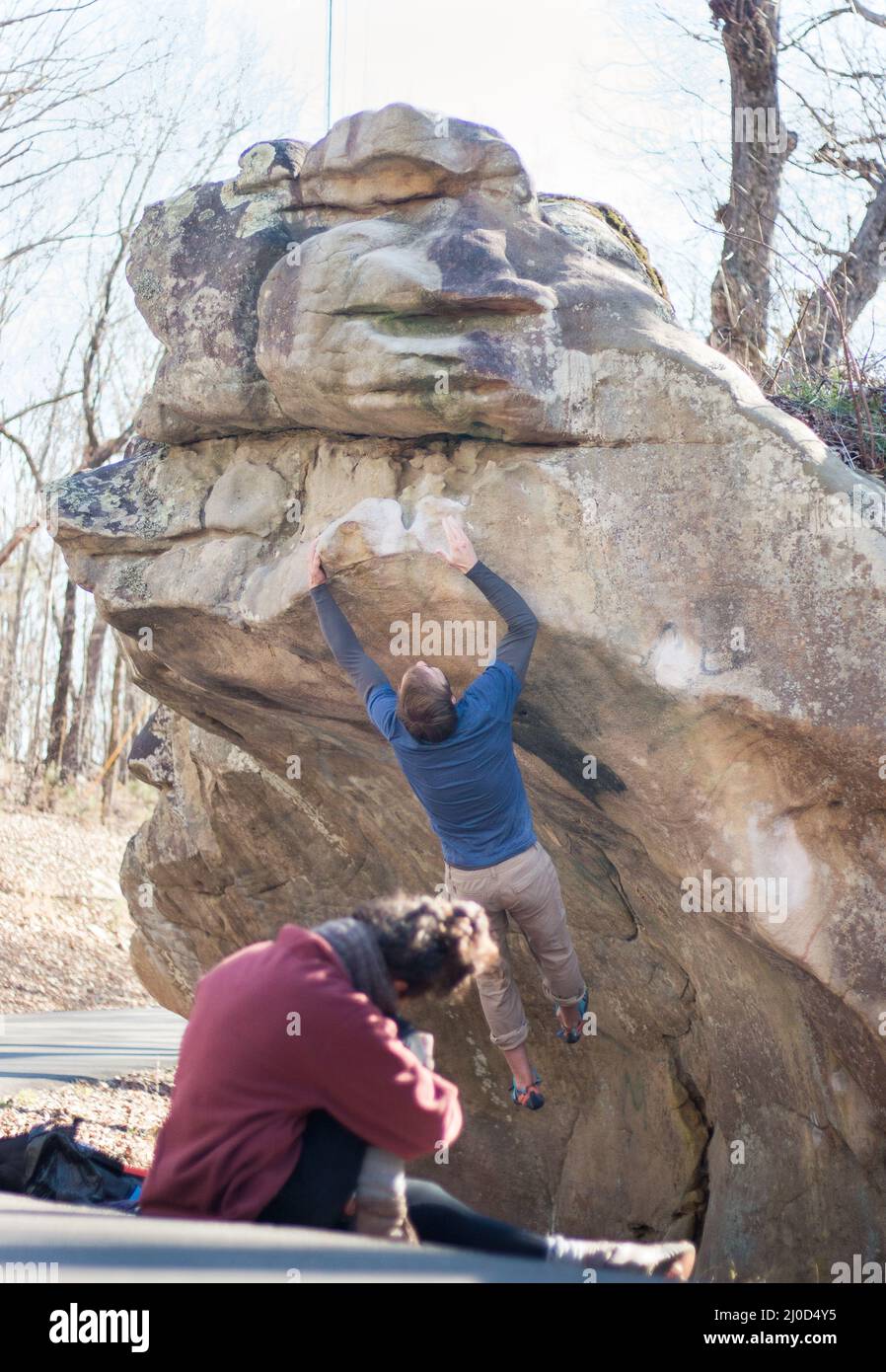 Strong male rock climber jumps to complete sandstone boulder, wife ...