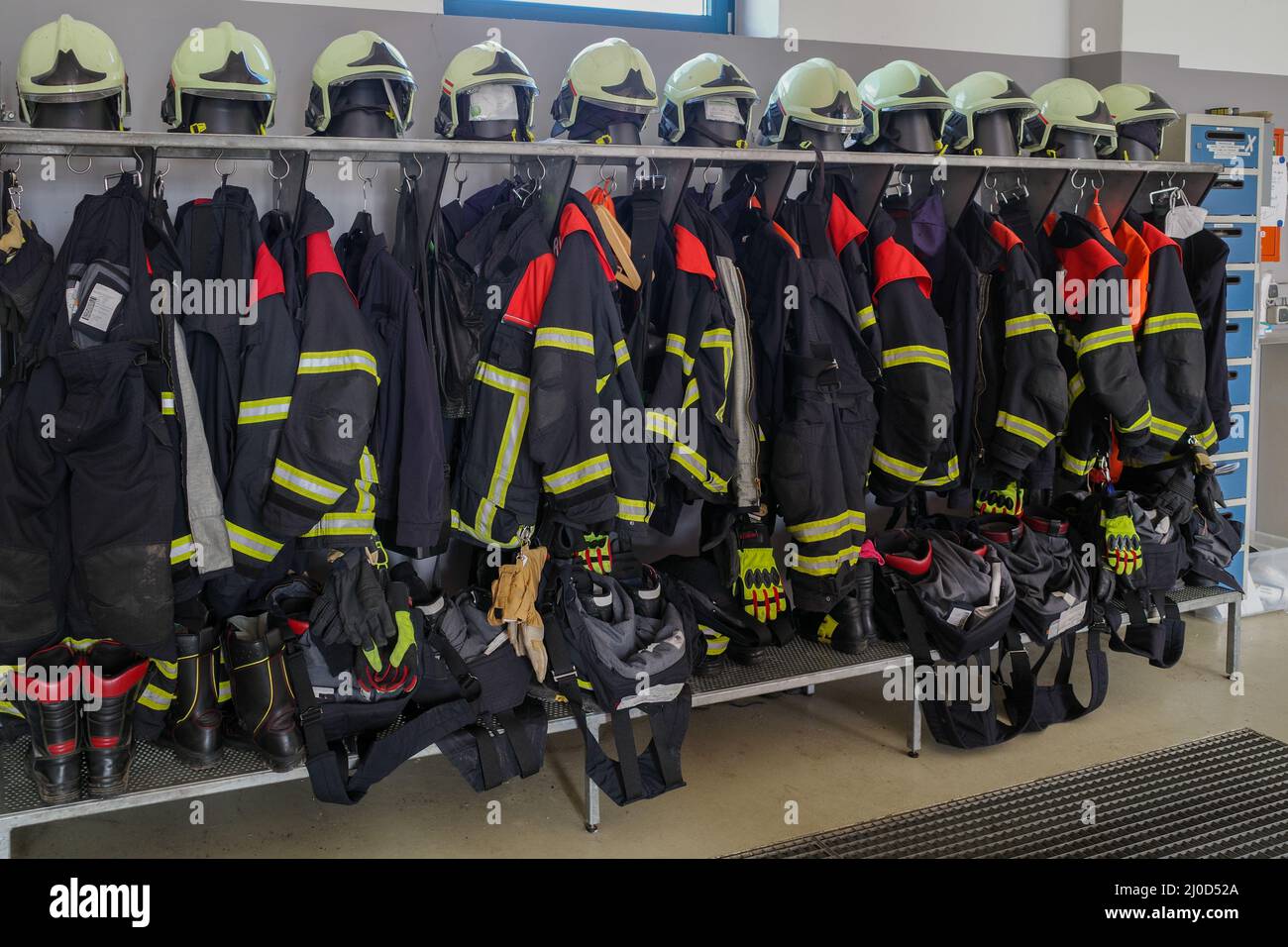 in a fire department hang many uniforms of firefighters next to each ...