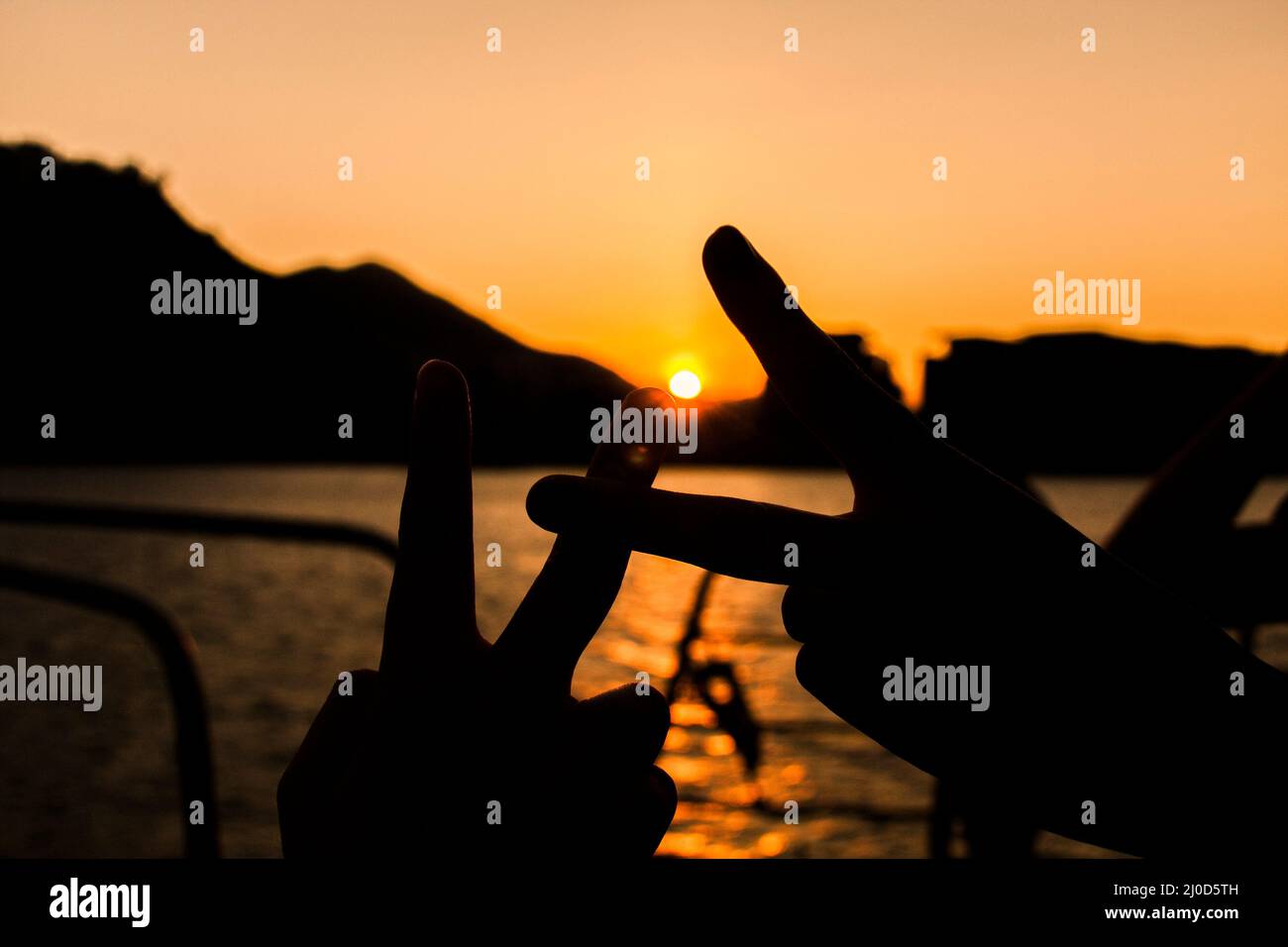 silhouette of v sign, peace sign, victory sign at sunset Stock Photo ...