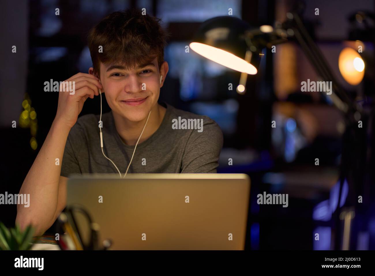 Teenage student learning at home with books and laptop computer. Online ...