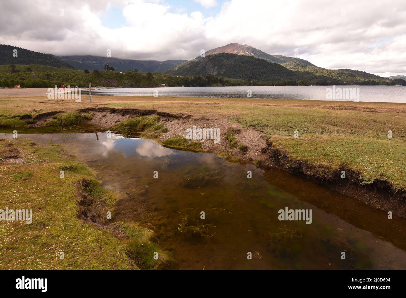 Small river stream passing in the village with the lake and mountains ...
