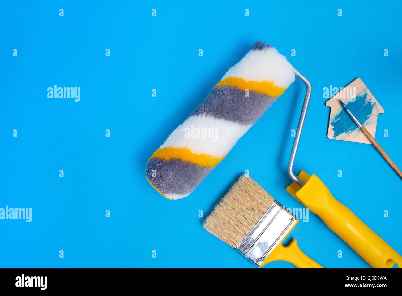 Paint roller, shield brush for painting walls on a blue background and ...