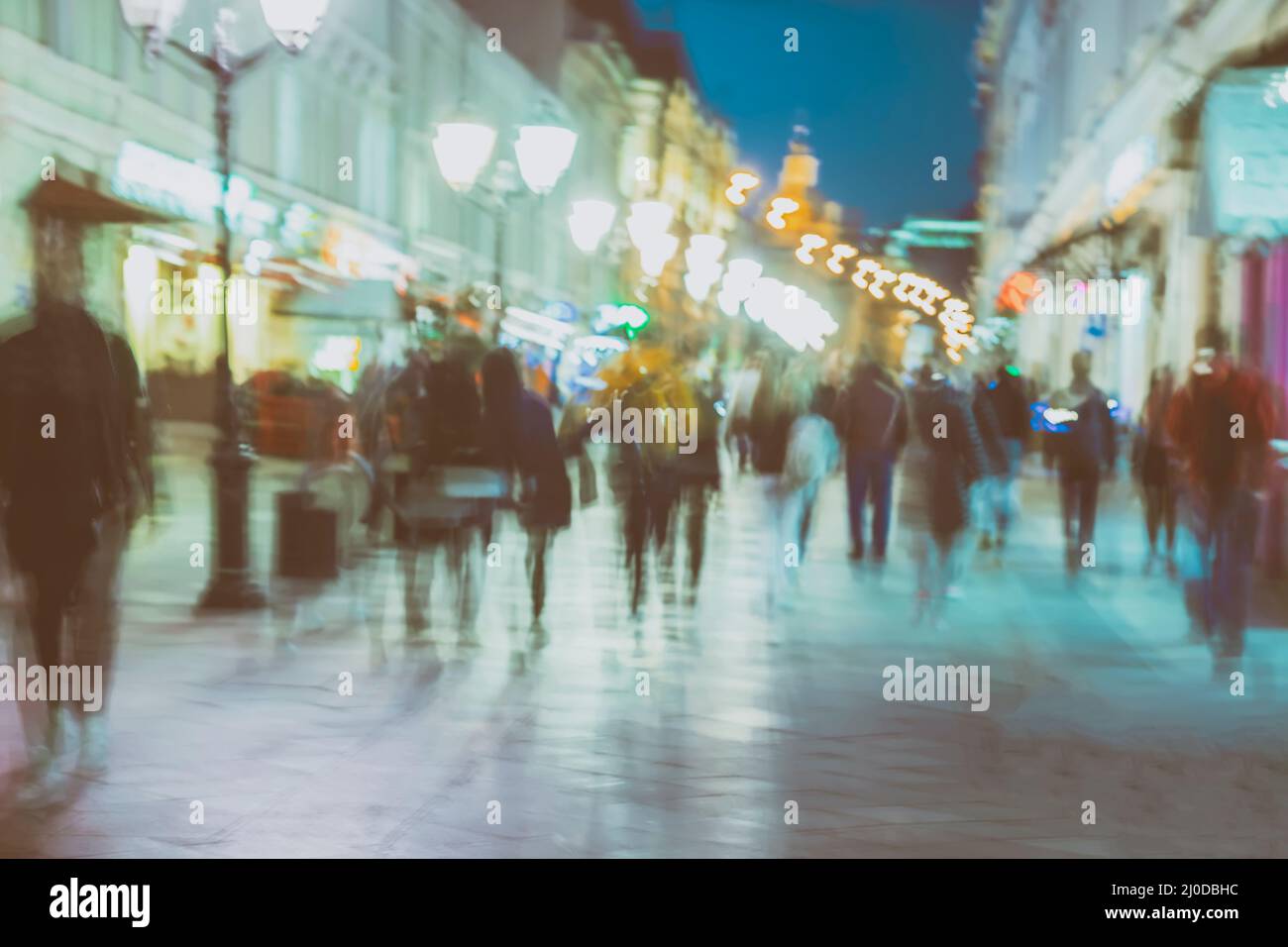 Abstract city street in evening, blurred background. People walking ...