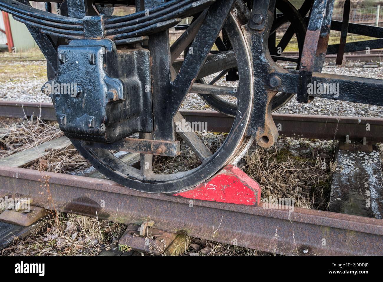 Wheel of carriage held by chock on line Stock Photo - Alamy