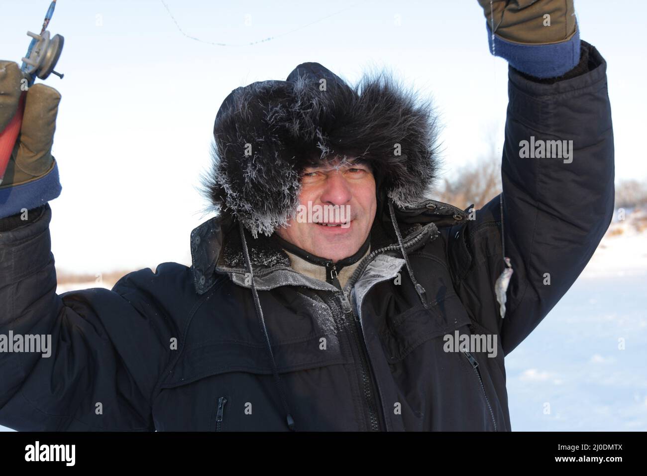 The winter fisherman poses with a caught fish Stock Photo - Alamy