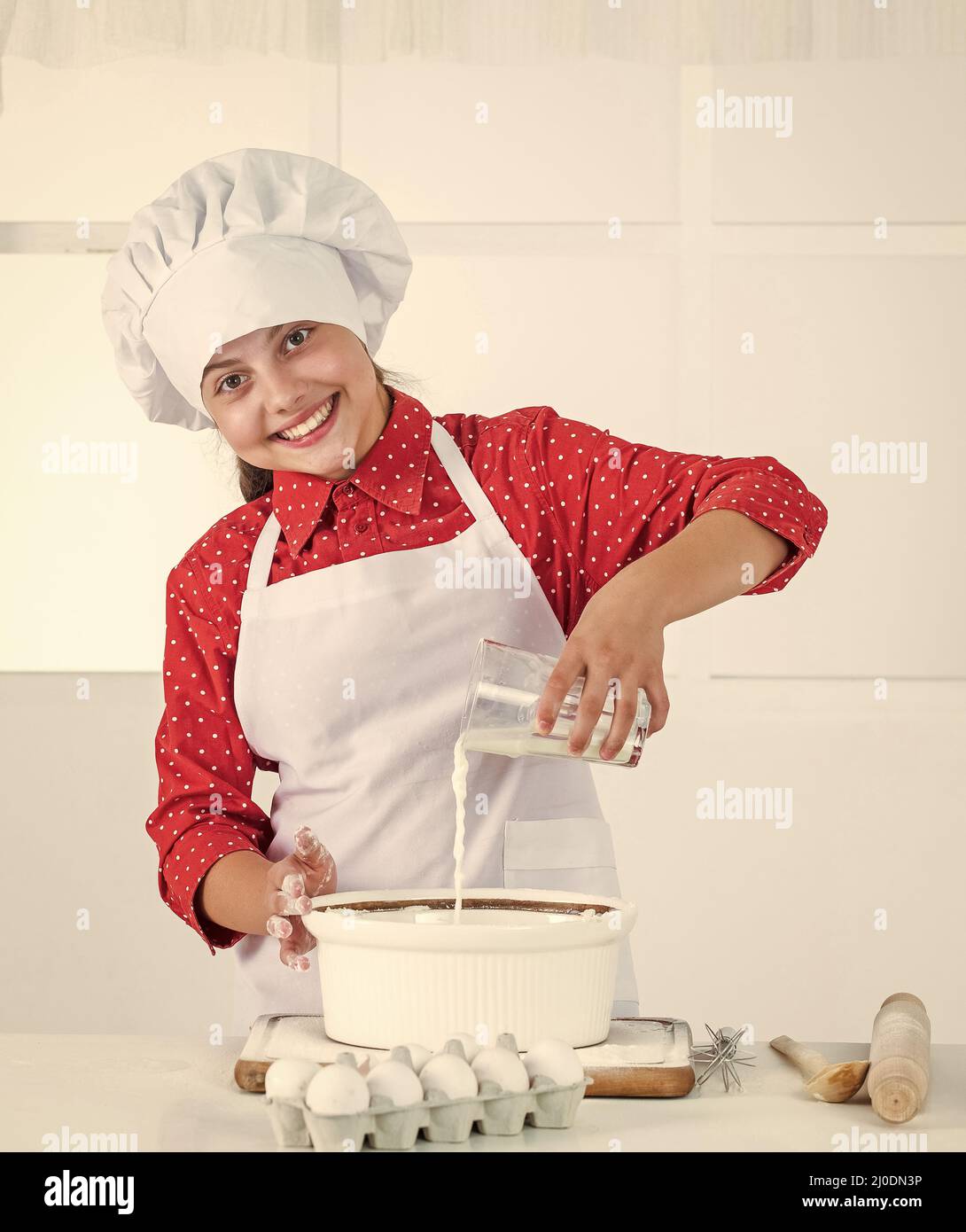 smiling teen girl in chef uniform cooking and baking, kitchen Stock ...