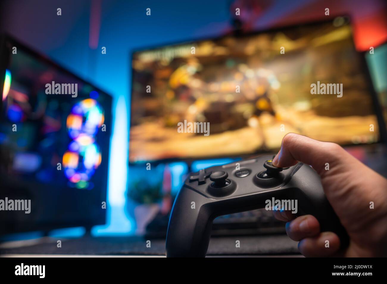 Modern gamepad in the gamer's hand. Video games on the big TV screen ...