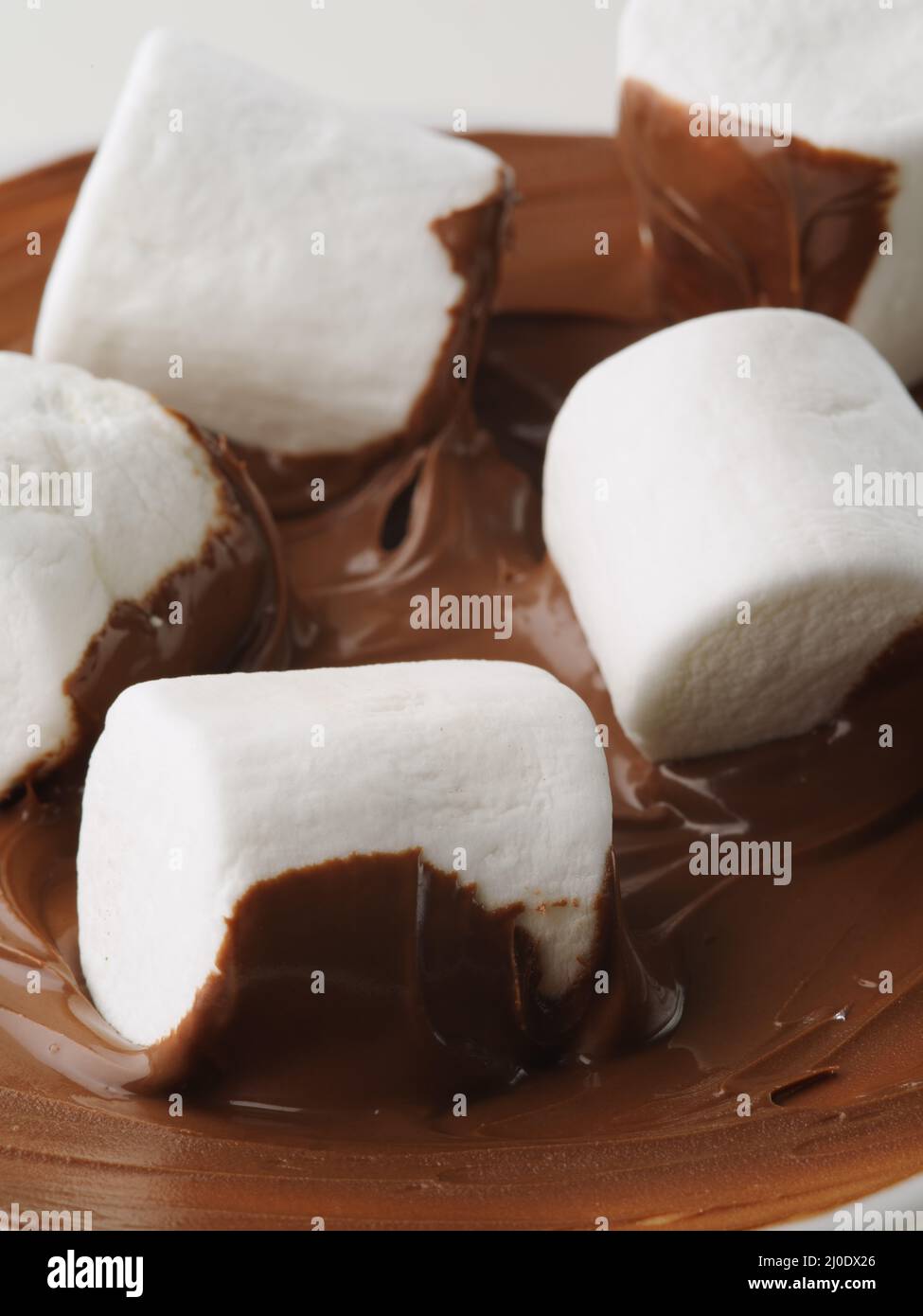 Macro shot. White marshmallow pieces in chocolate paste. Sweets ...