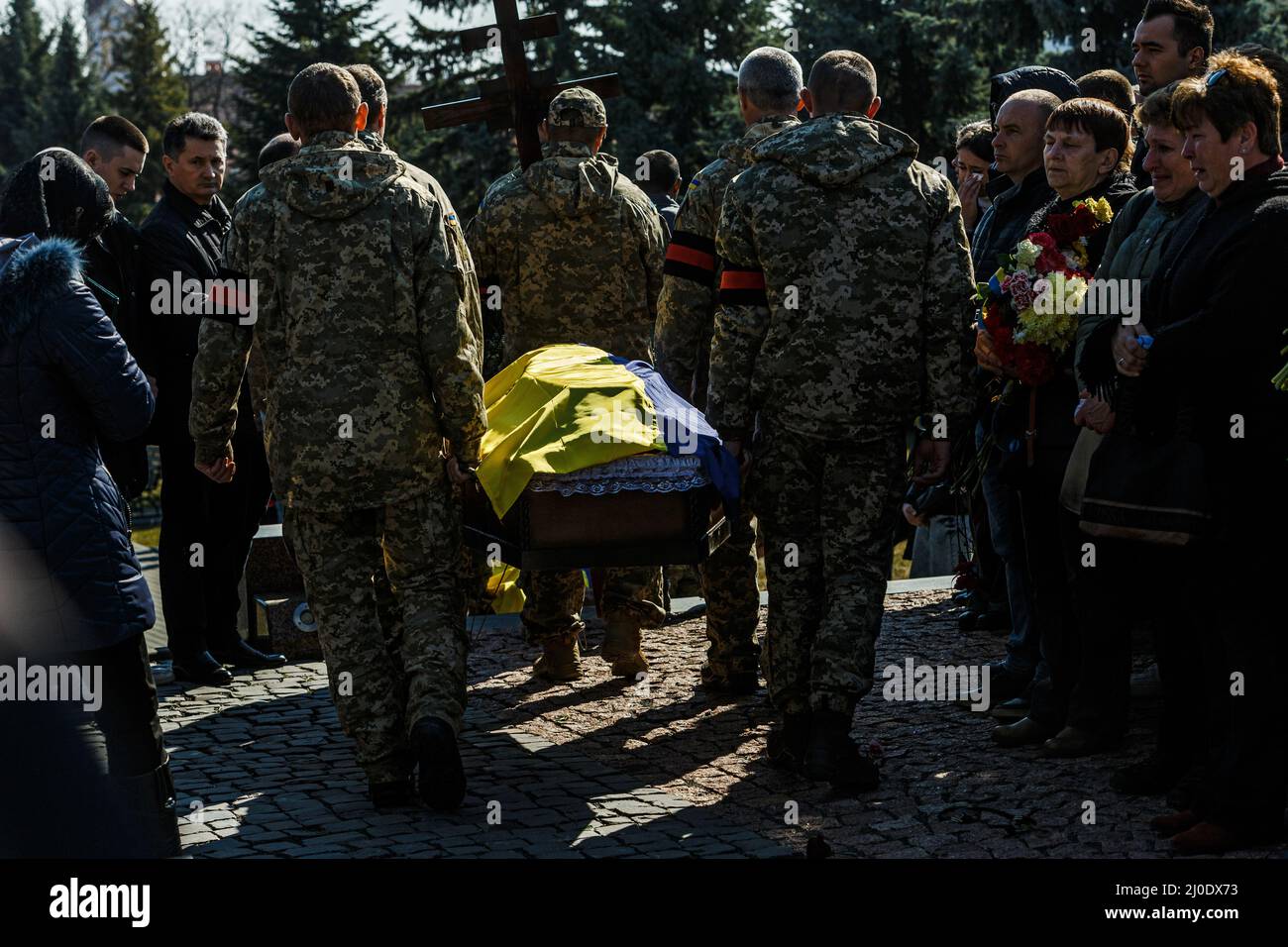 UZHHOROD, UKRAINE - MARCH 18, 2022 - Men in camouflage uniforms carry a ...