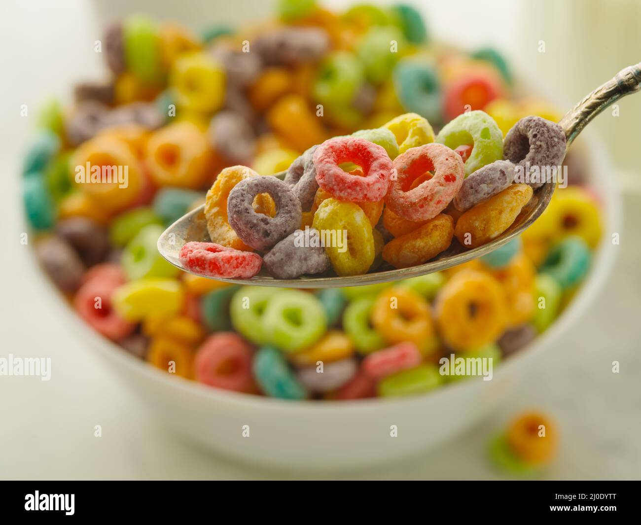 Colored fruit whole grain rings in a spoon and bowl. Macro shot ...