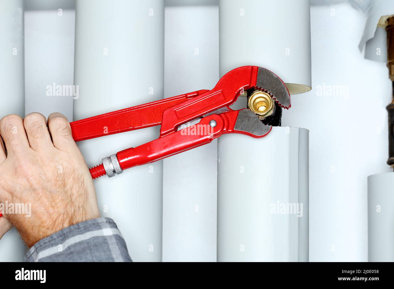 Worker with red gripper in hand is mounting Stock Photo - Alamy
