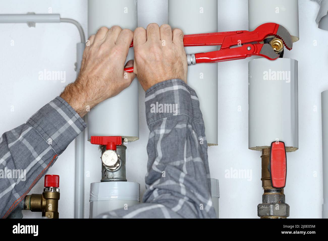 Repairing a valve with a red gripper Stock Photo - Alamy