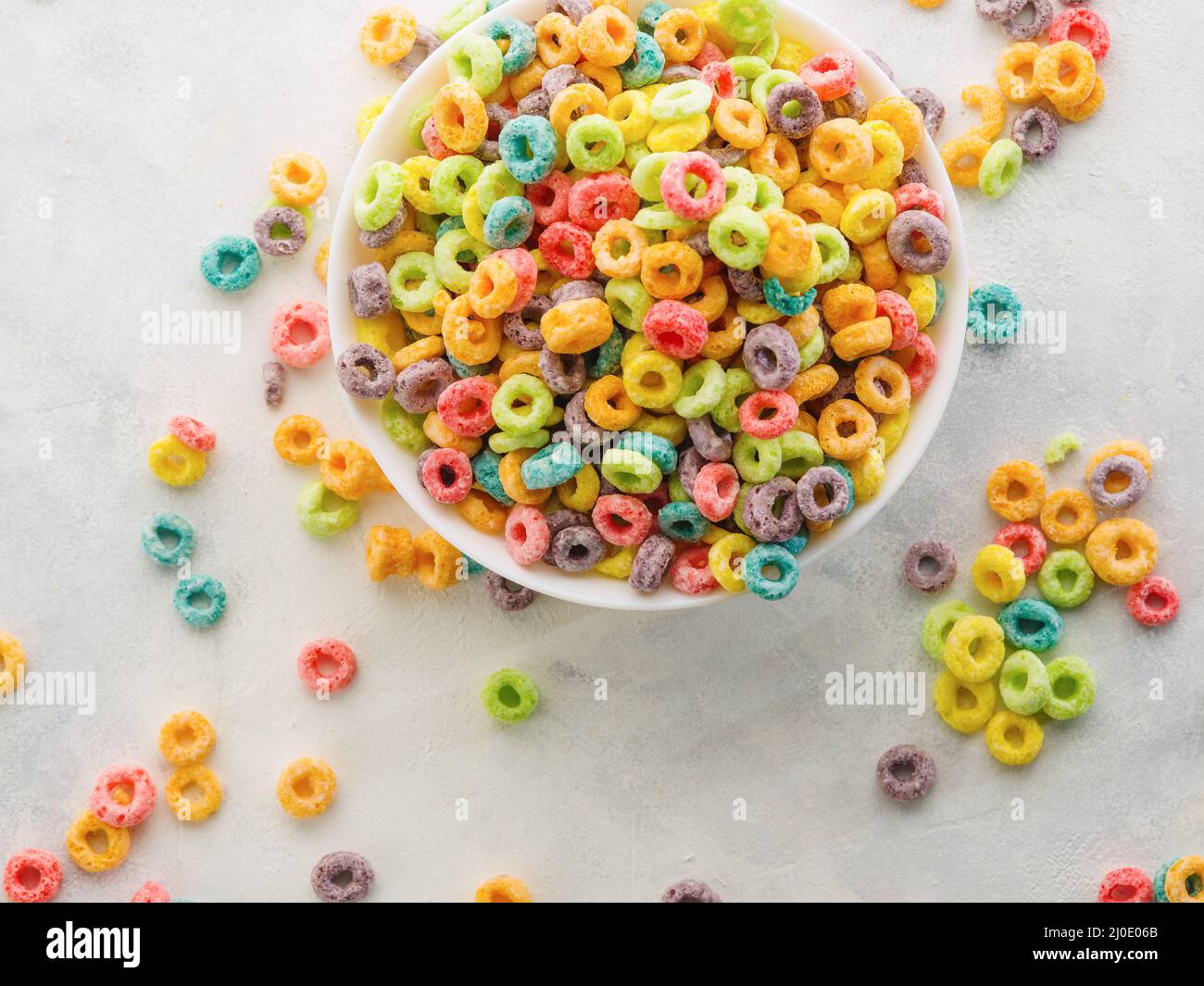 On a white background, multi-colored fruit cereal rings. High angle ...