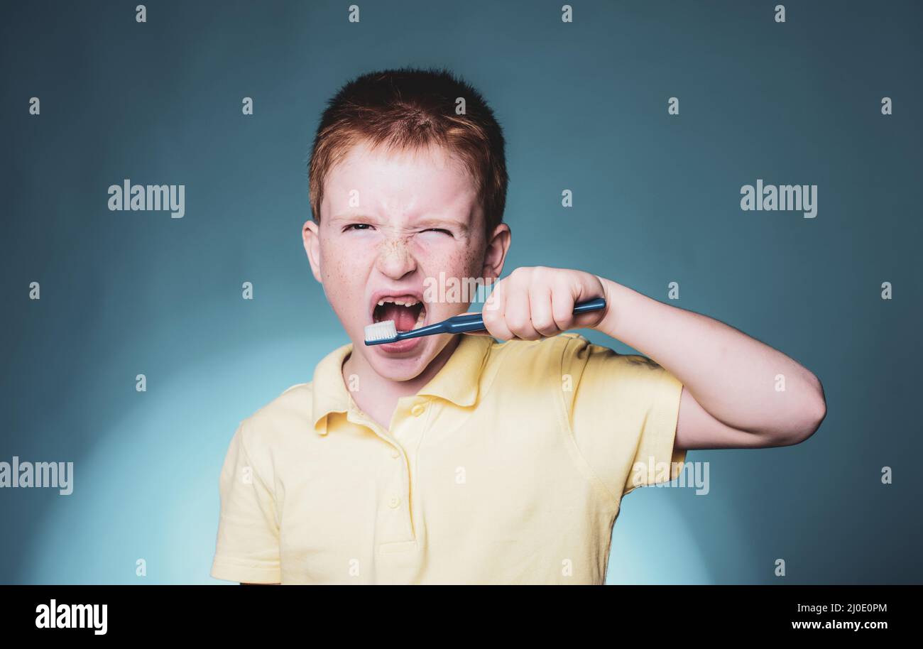 Adorable little boy holding toothbrush and smiling at camera. Mockup ...