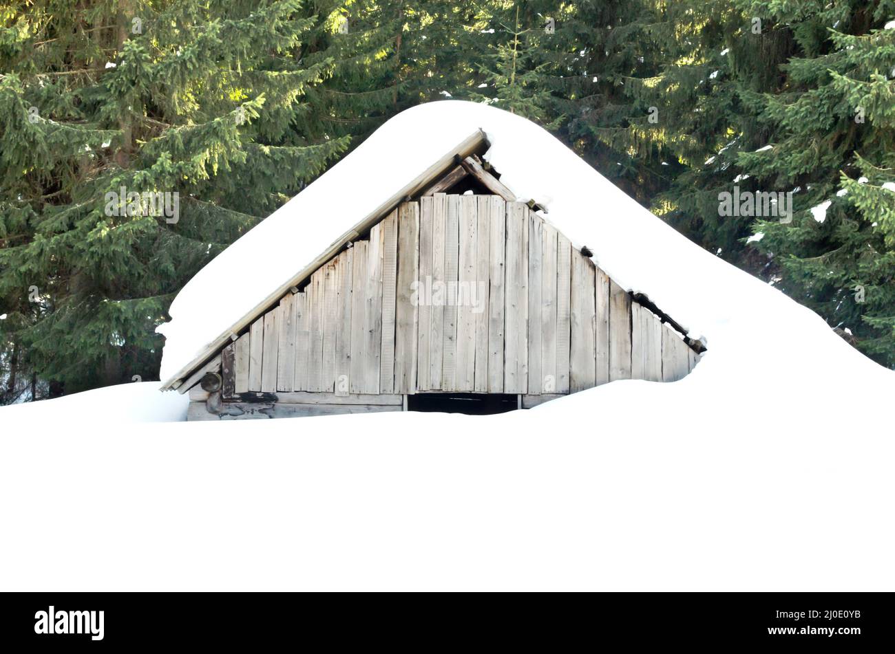 Wooden house covered with snow in the winter forest. The concept of ...